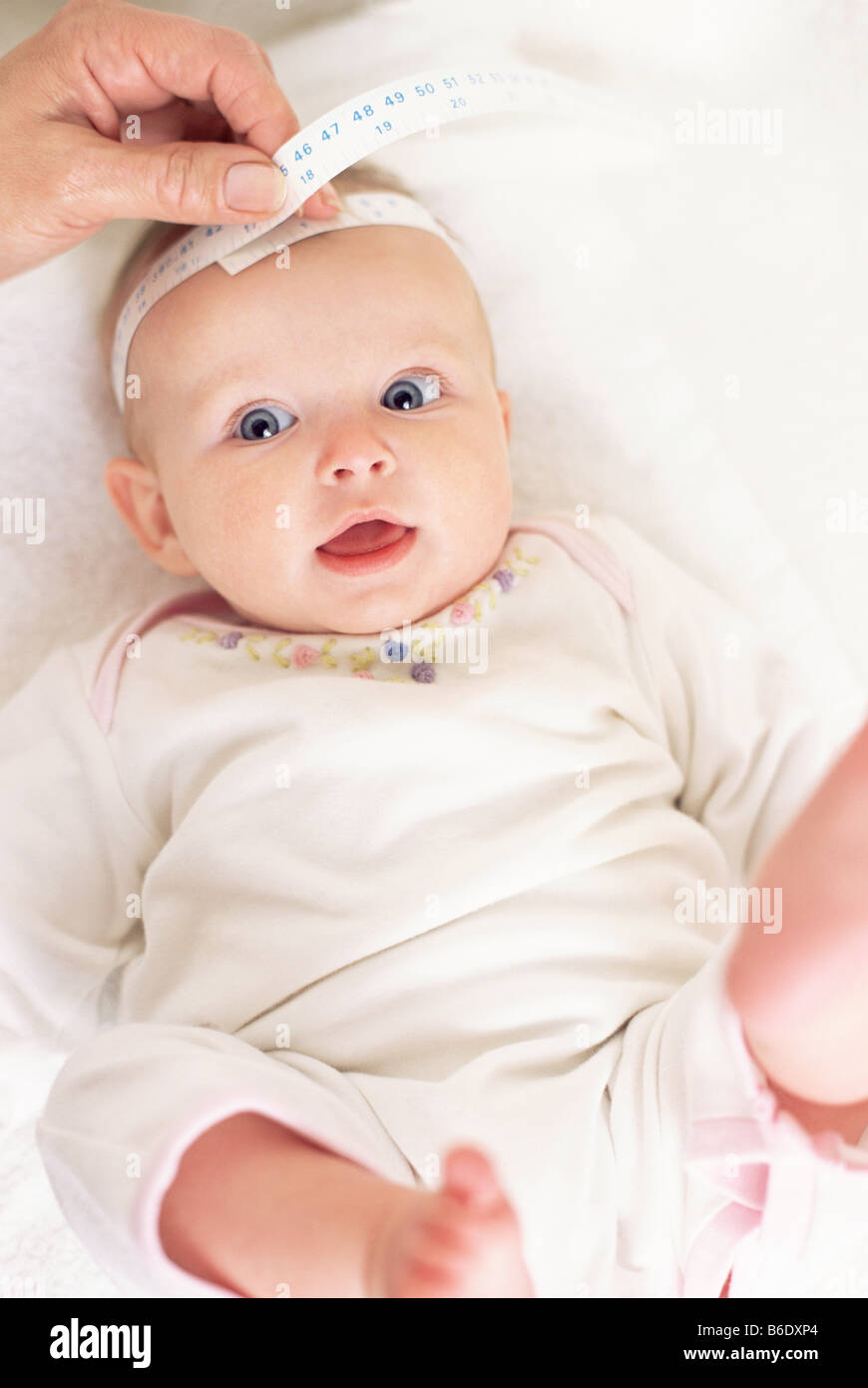 Paediatric examination. Tape measure being used to measure the ...