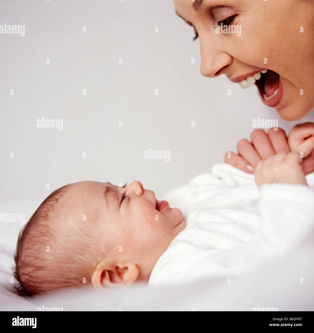 Mother and baby girl. Mother and her 12 week old baby girl smiling as ...