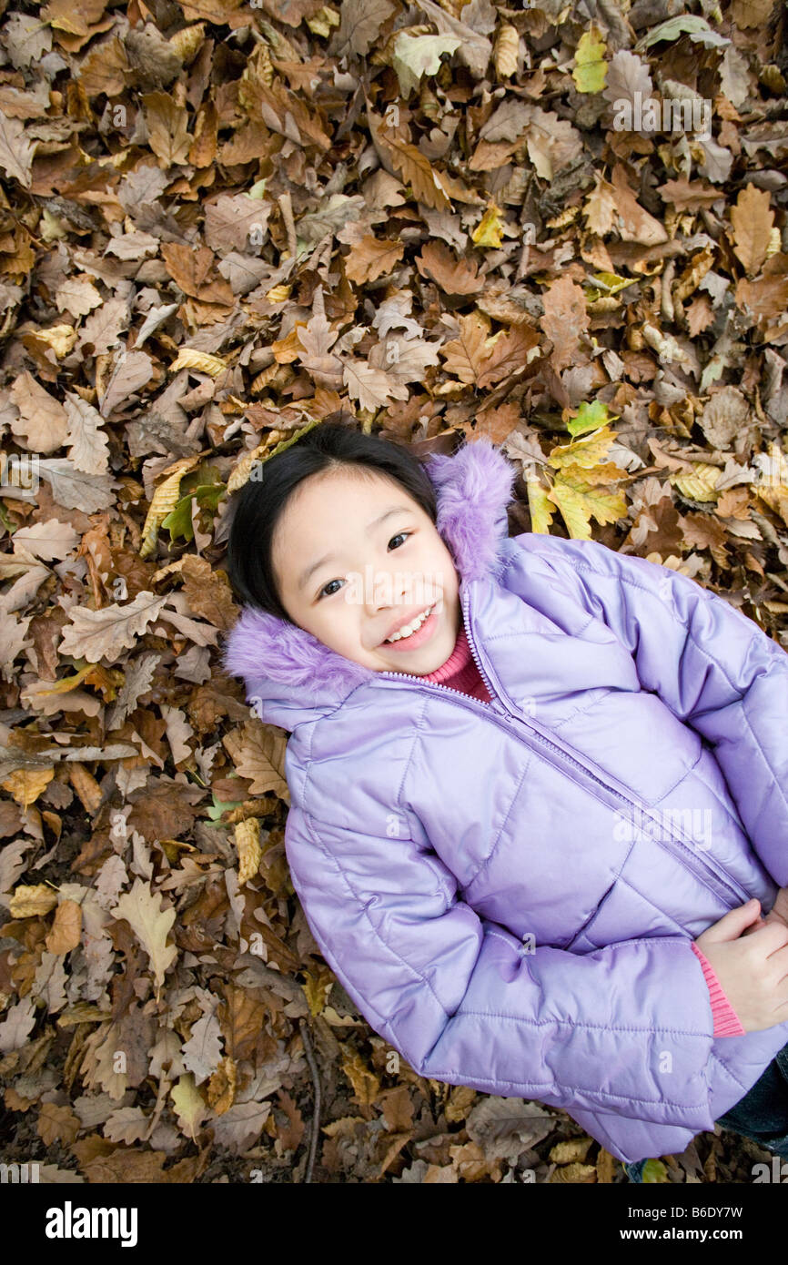 Smiling girl lying on autumn leaves Stock Photo - Alamy