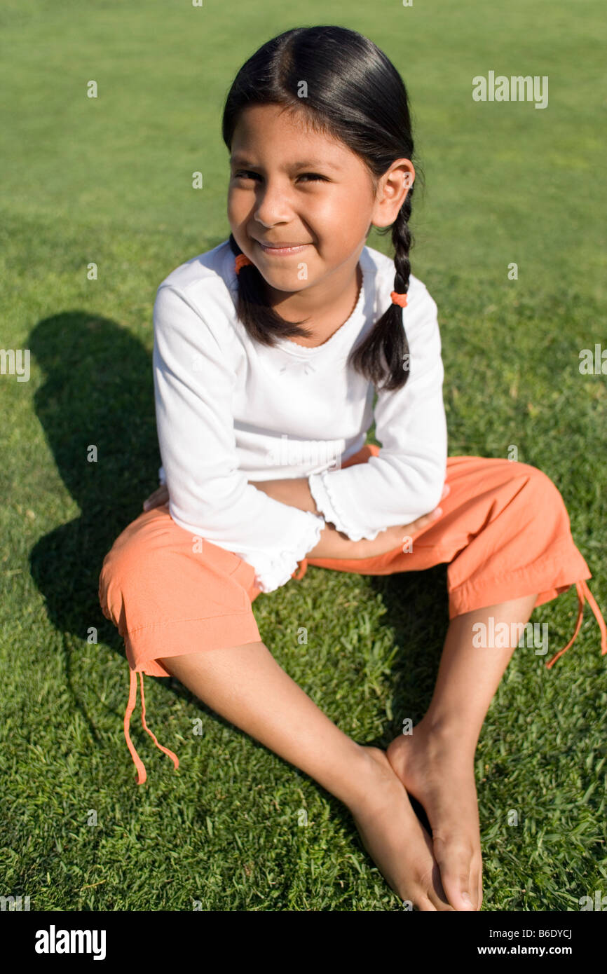 Smiling girl sitting on grass Stock Photo - Alamy