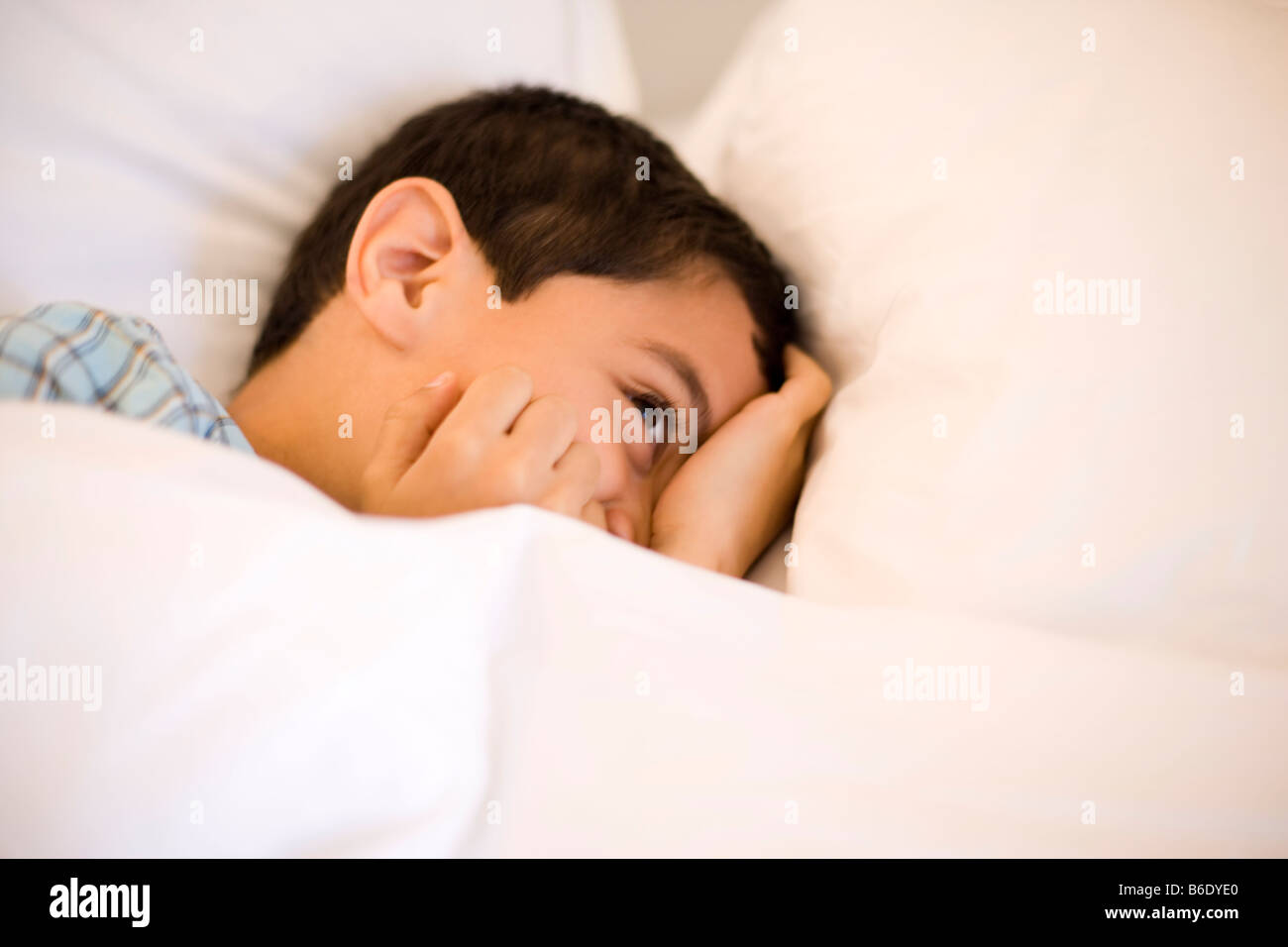 Young boy playfully hiding his face Stock Photo - Alamy