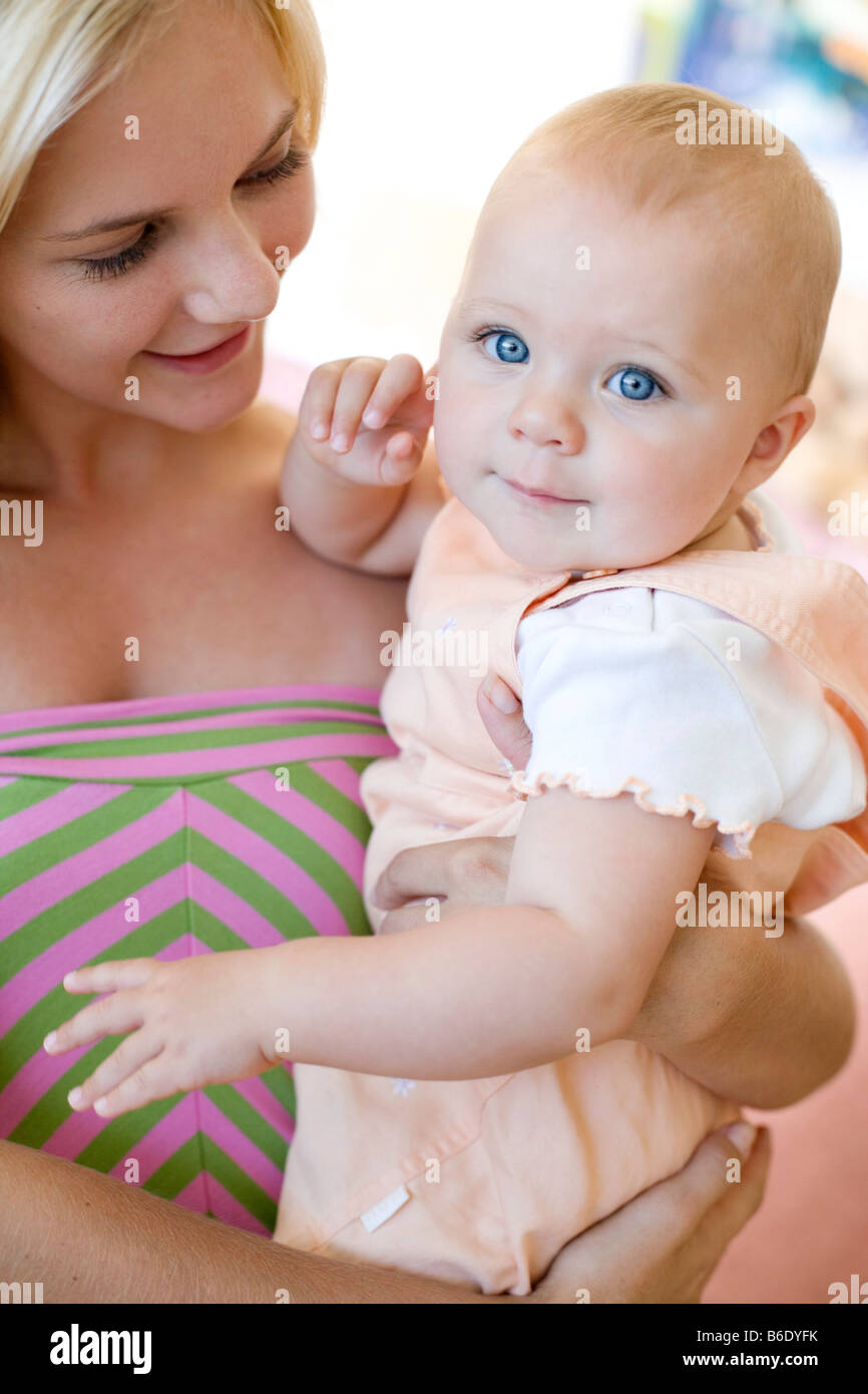 Teenage mother and baby. Young mother holding her 10 month old daughter ...