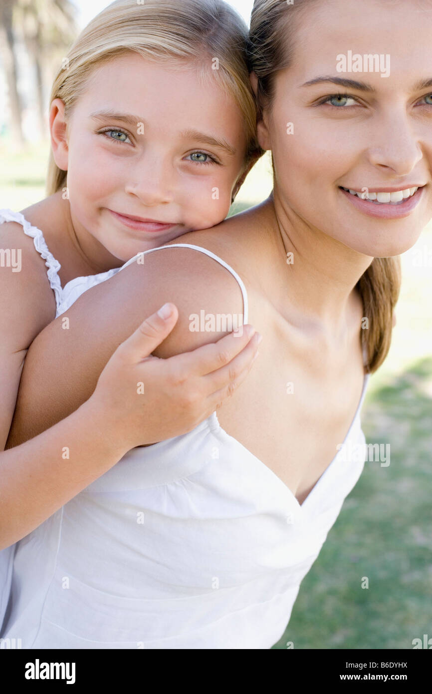 Mother carrying her daughter on her back Stock Photo - Alamy