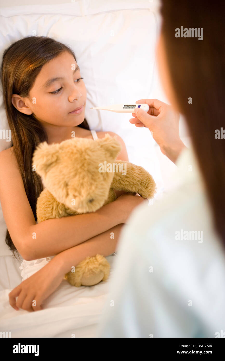 Ill child. Mother showing her daughter her temperature reading on an ...