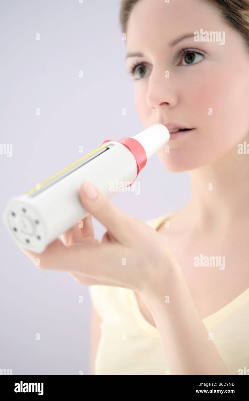 Lung function test. Twenty five year old woman breathing into a ...