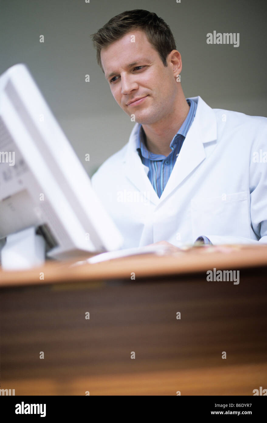 Doctor typing notes on a computer in his office Stock Photo - Alamy