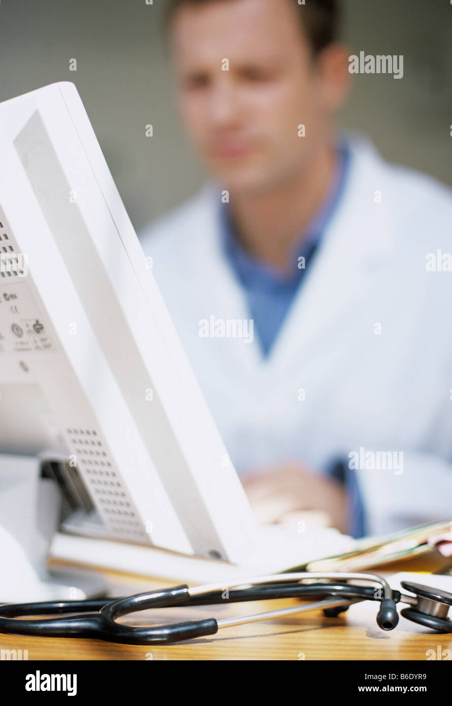 Doctor typing notes on a computer in his office Stock Photo - Alamy