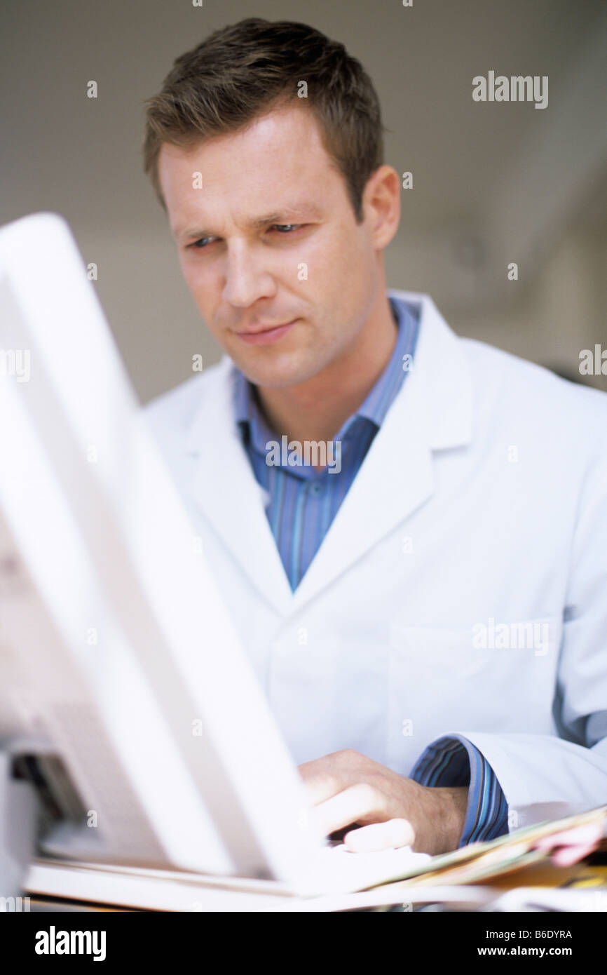Doctor typing notes on a computer in his office Stock Photo - Alamy