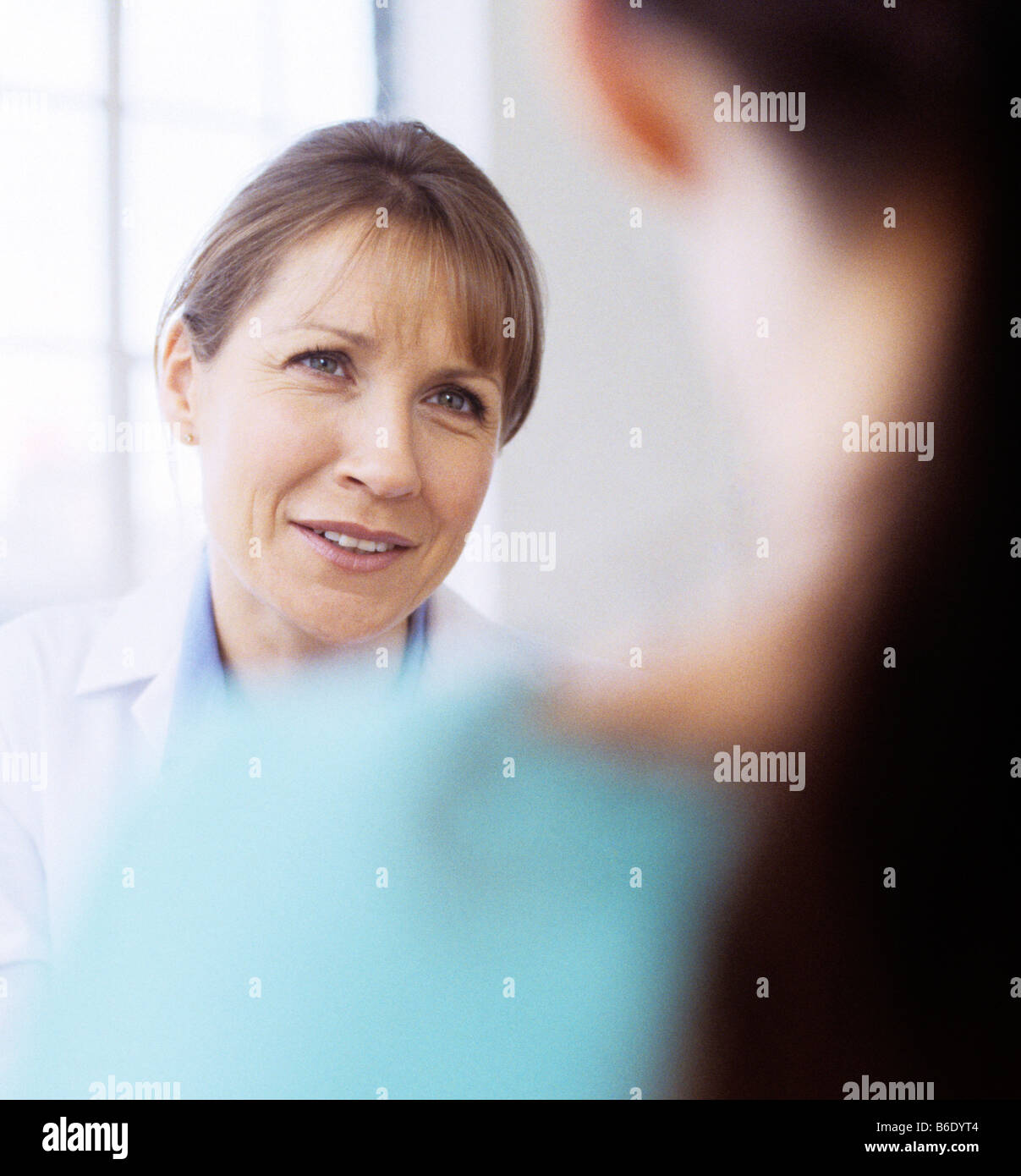 General practice doctor talking to a young female patient Stock Photo ...