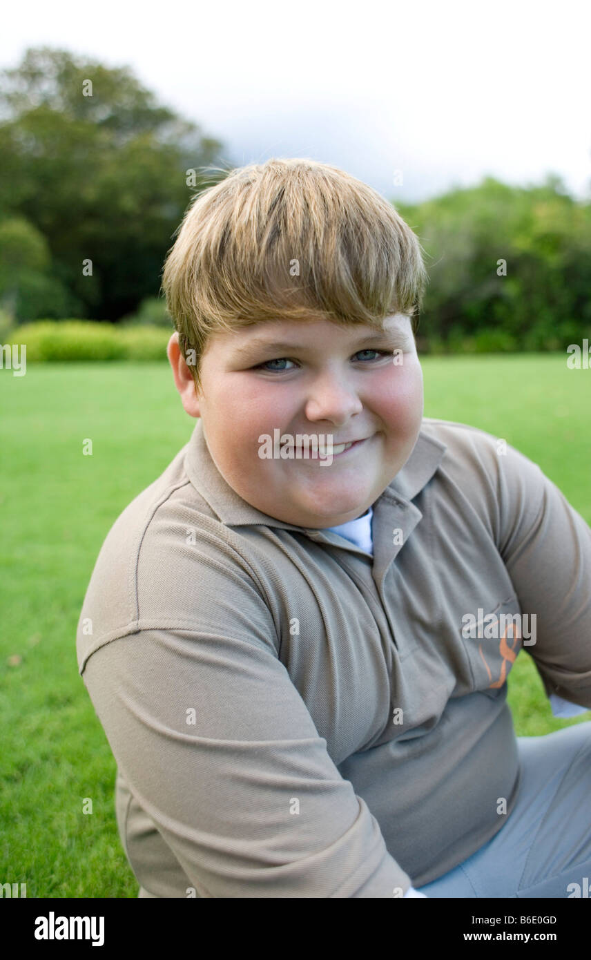 Happy boy sitting on grass Stock Photo - Alamy