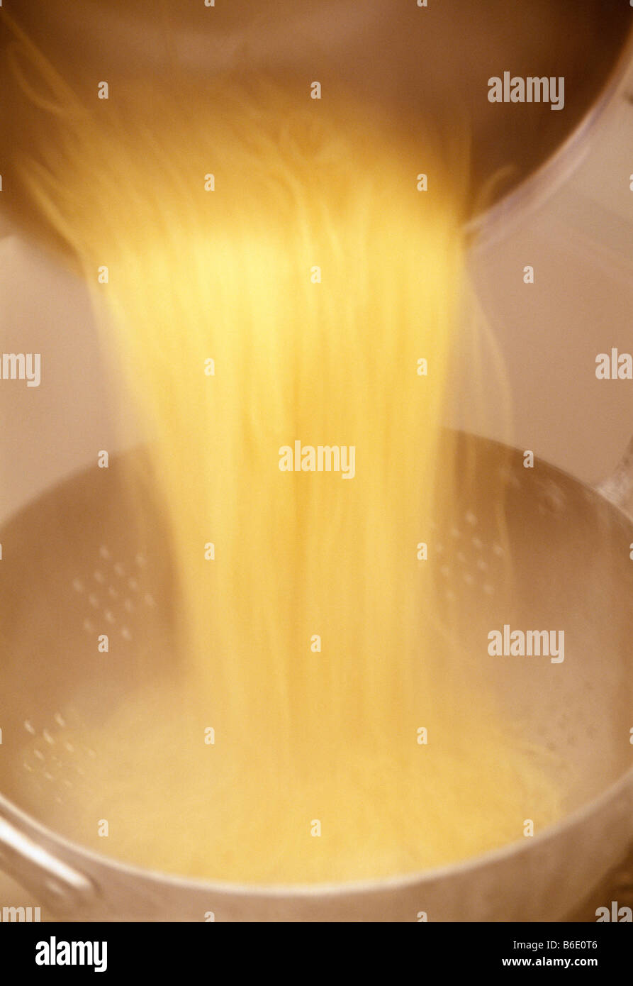 Draining spaghetti. Boiling water being drained from cooked spaghetti ...