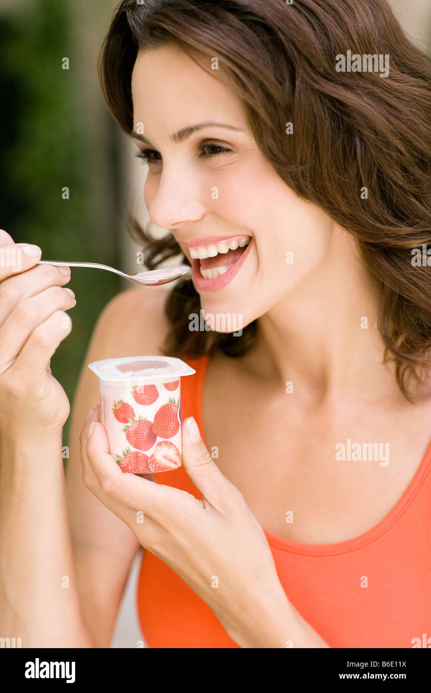 Woman eating yoghurt Stock Photo - Alamy