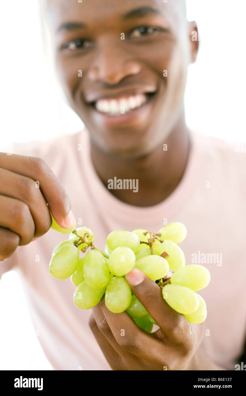 Healthy eating. Man eating a bunch of grapes Stock Photo - Alamy