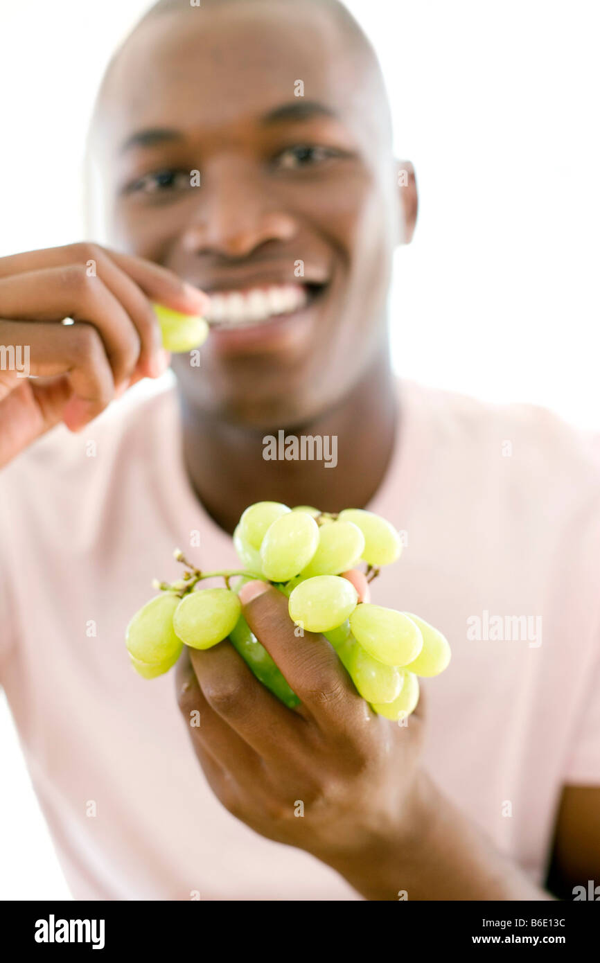 Healthy eating. Man eating a bunch of grapes Stock Photo - Alamy