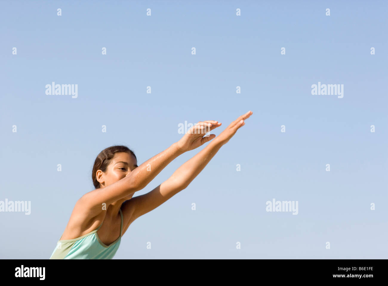 Girl throwing. Girl with her arms extended after throwing a ball in a ...
