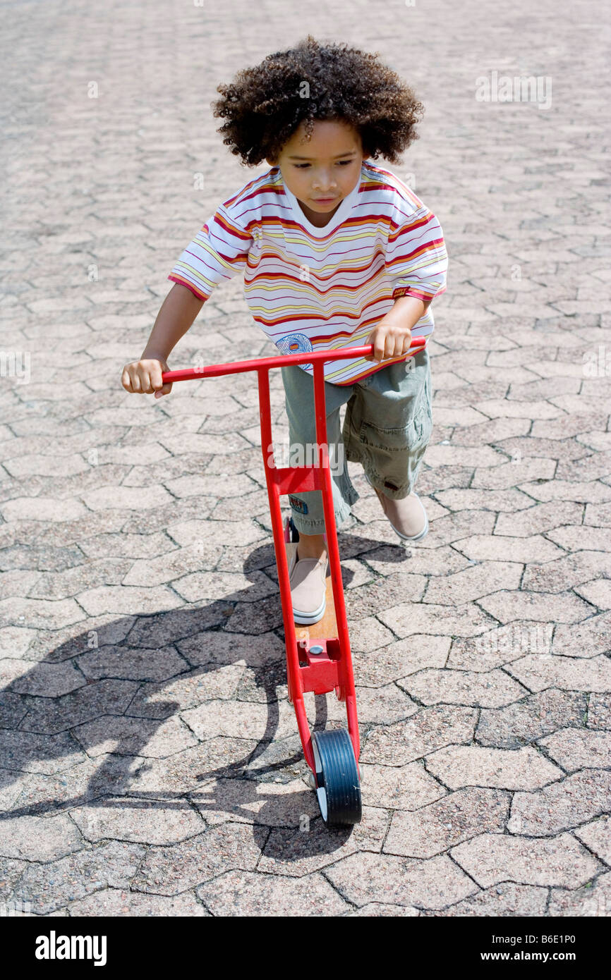 Boy riding a toy scooter Stock Photo - Alamy