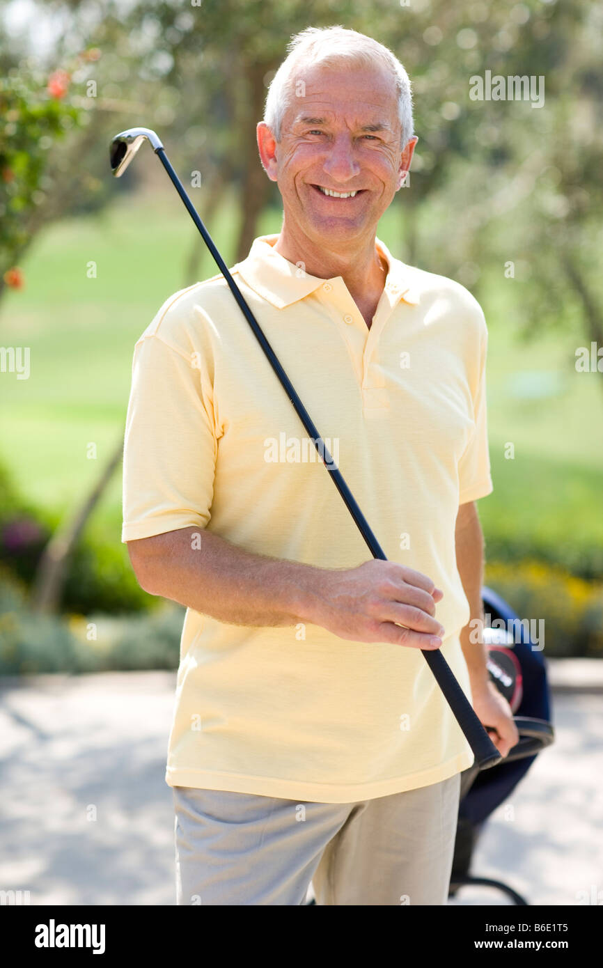Golf player. Man holding a golf club and pulling his golf bag on a ...