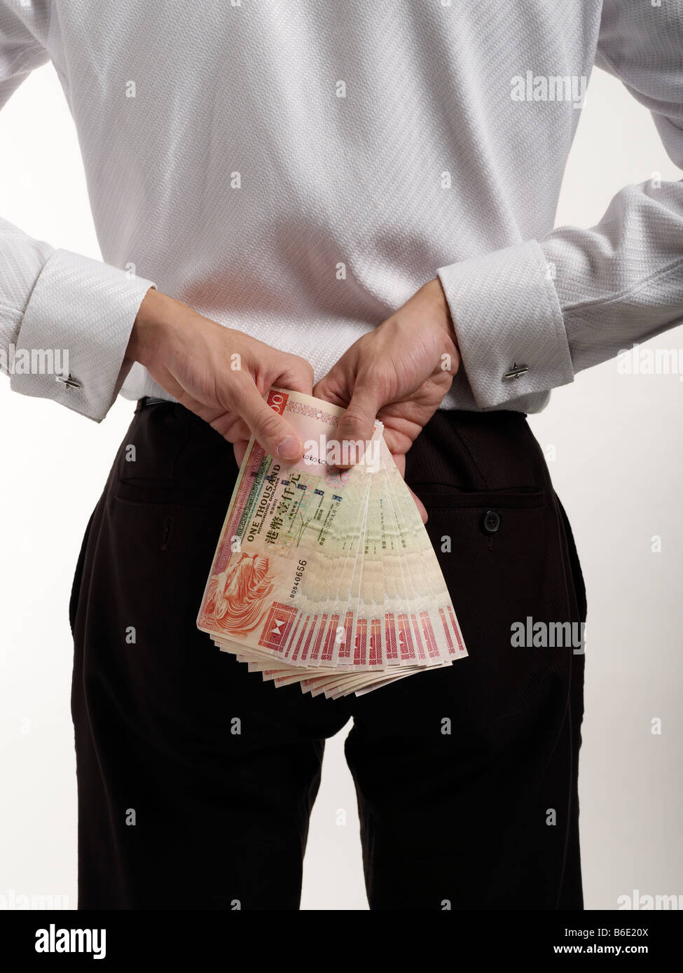 Businessman banknotes behind back, mid section Stock Photo - Alamy