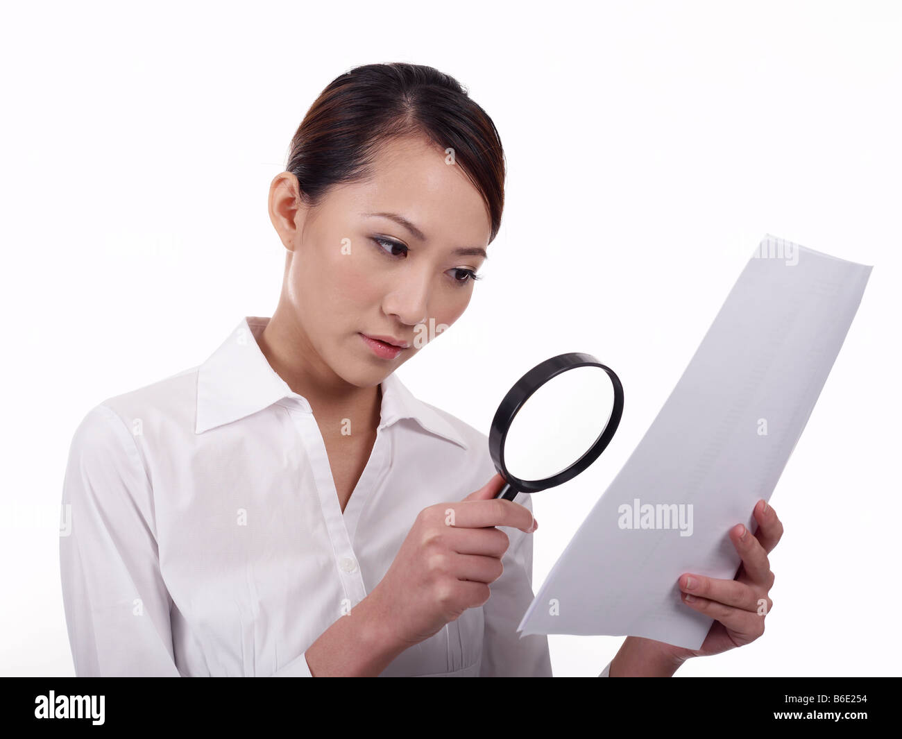 Businesswoman using a magnifying glass to read Stock Photo - Alamy