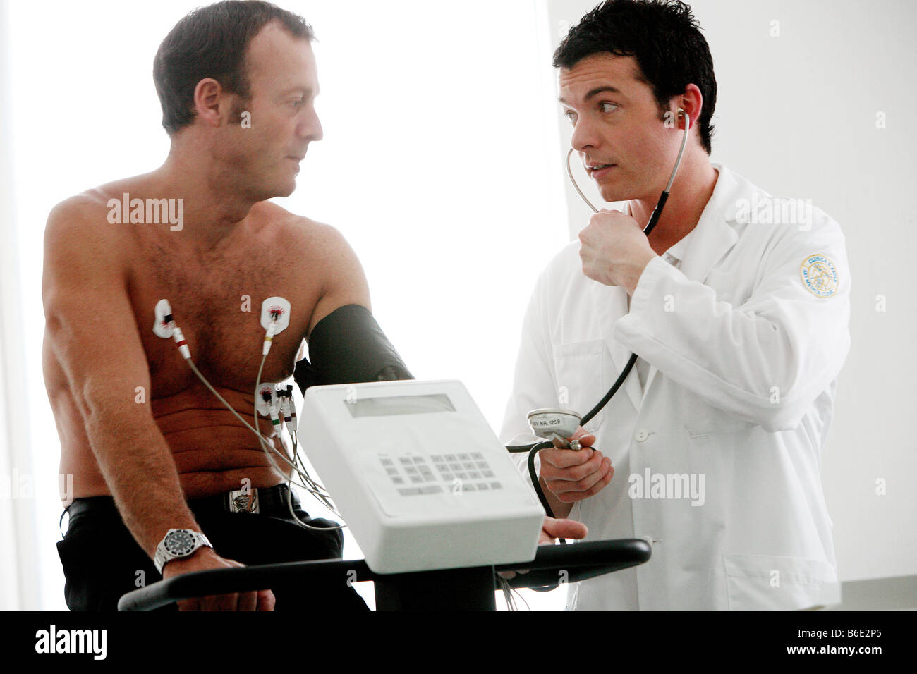Heart fitness test. Doctor using astethoscope and arm cuff to measure a ...