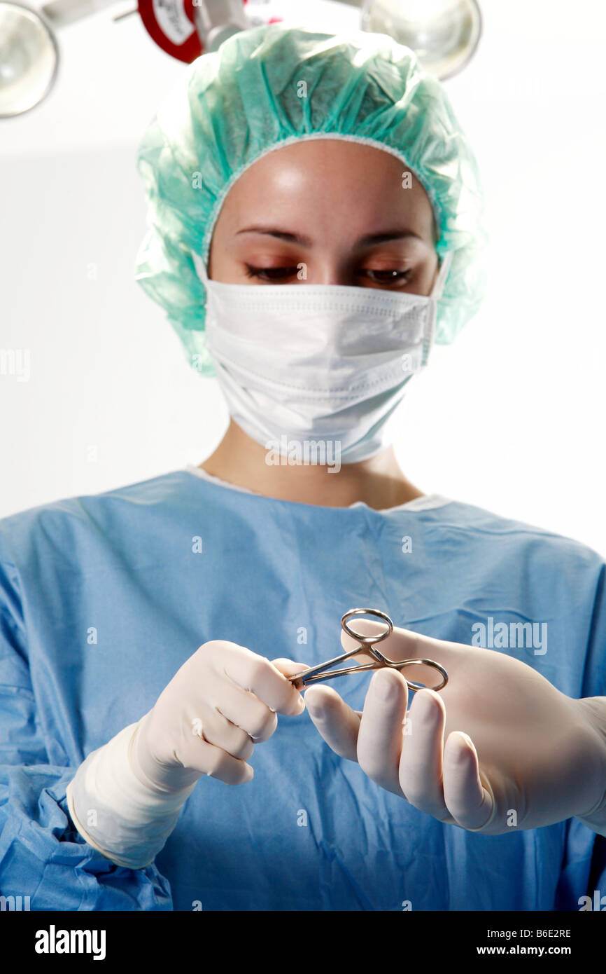 Surgery. Surgical assistant passing forceps to a surgeon during an ...