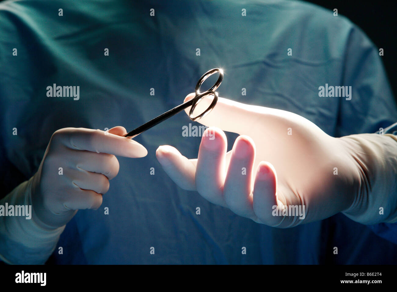 Surgery. Surgical assistantpassing forceps to a surgeon during an ...