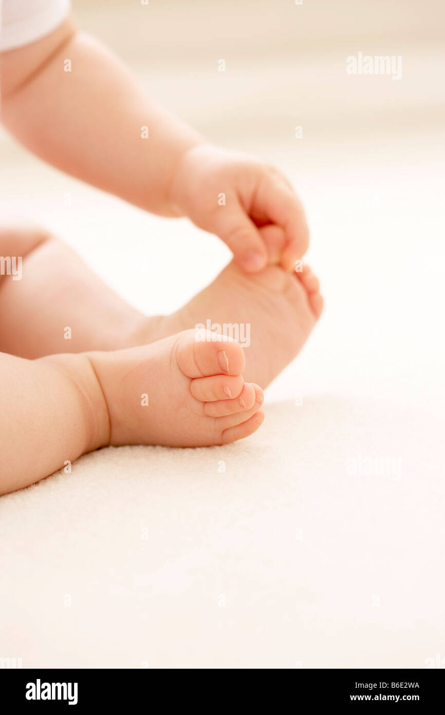Baby grasping her big toe Stock Photo - Alamy