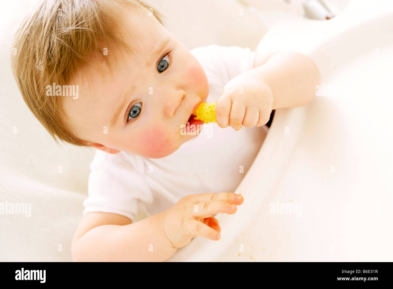 Baby boy eating a crisp Stock Photo - Alamy