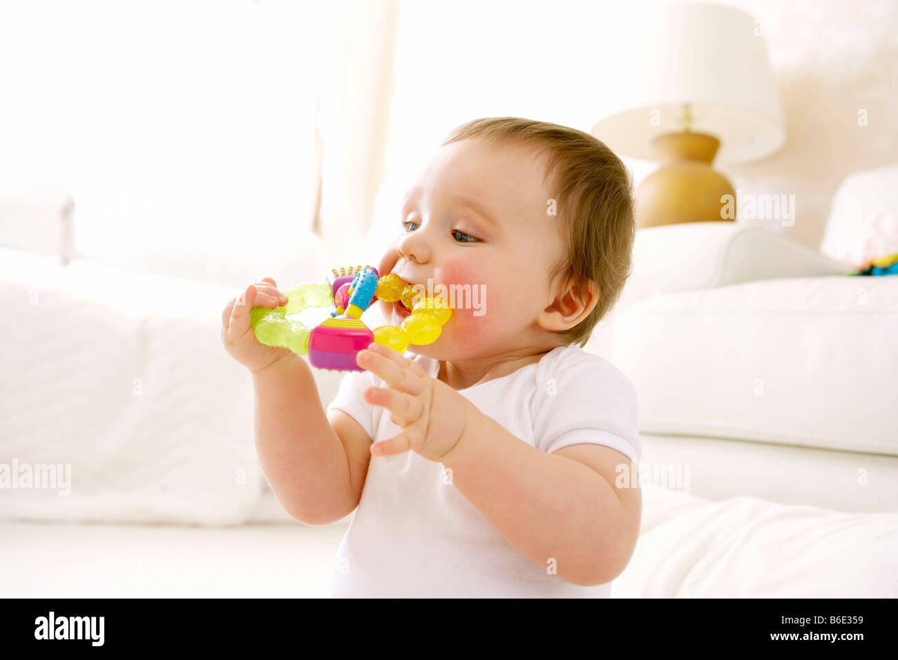 Baby boy chewing on teething ring Stock Photo - Alamy