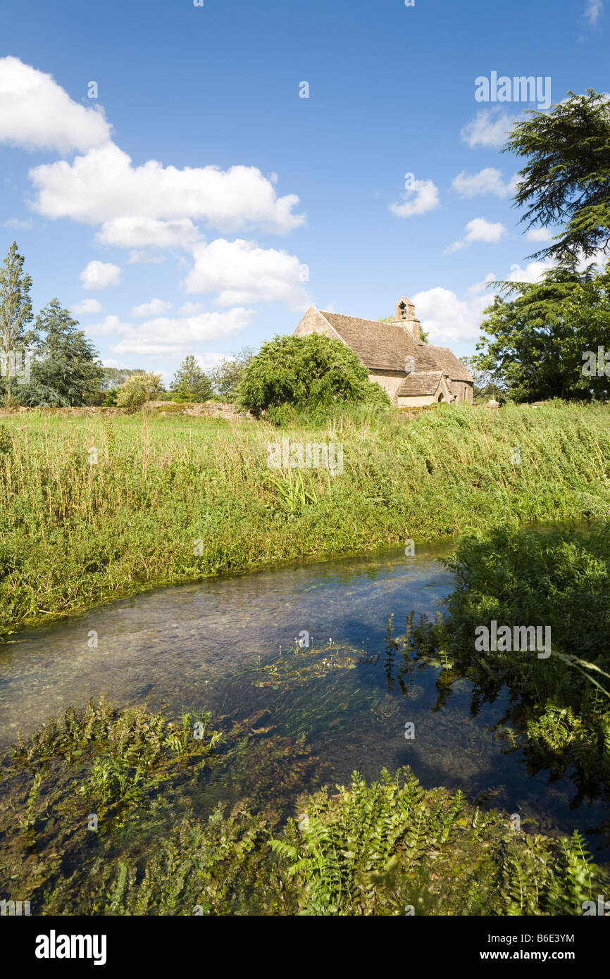 The 12th century Cotswold church of St Mary beside the Ampney Brook at ...