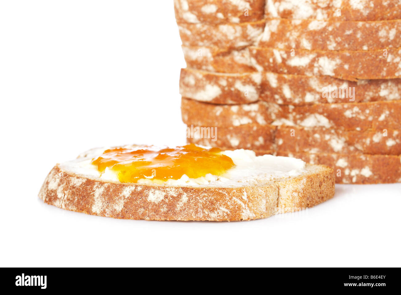 Toast with butter and peach jam and bread pile with soft shadow on ...