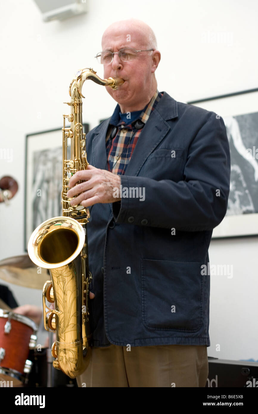 An elderly musician plays the saxophone at a lunchtime concert Stock ...