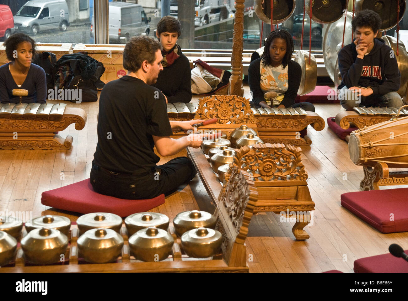 GROUP OF YOUNGSTERS LEARNING HOW TO PLAY VARIETY OF MUSICAL INSTRUMENT ...