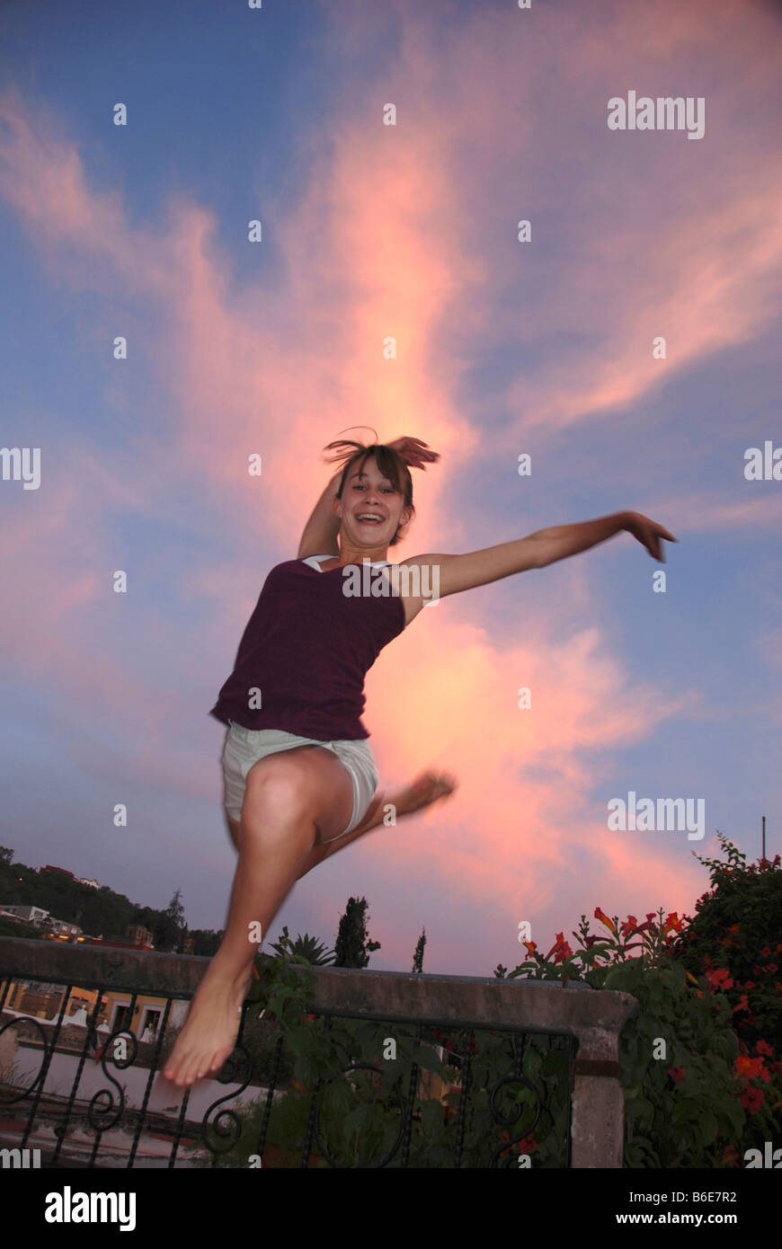Teenage caucasian girl leaping with a sunset in the background Stock ...