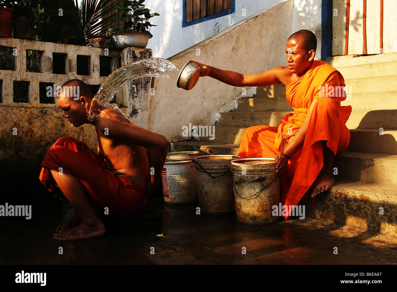 A Buddhist monk washes another at a monastery in the ruins of Angkor ...
