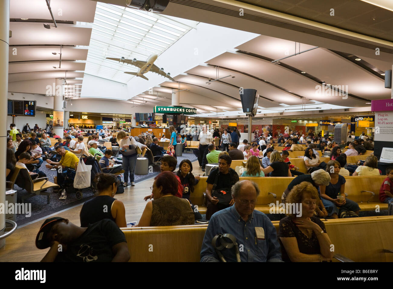 passengers waiting to board flights, Terminal three departure lounge ...