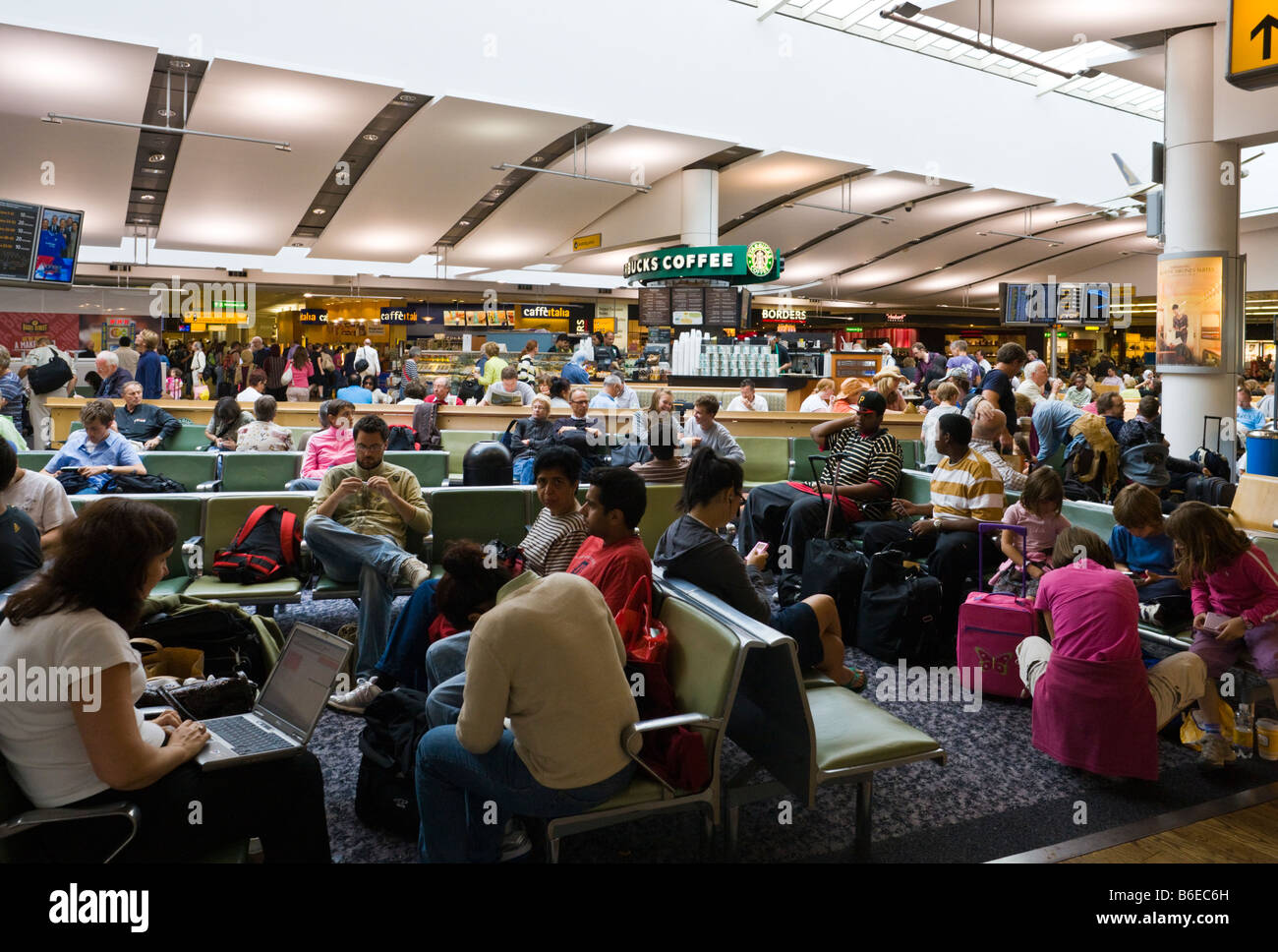 passengers waiting to board flights, Terminal three departure lounge ...