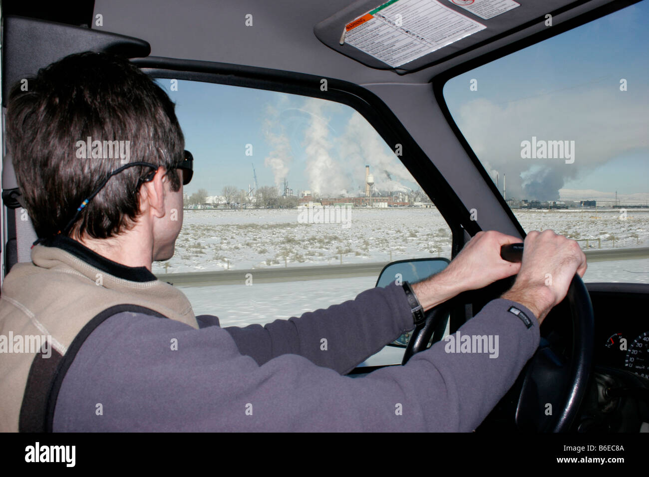 Man driving van past smokestacks out the window Stock Photo - Alamy