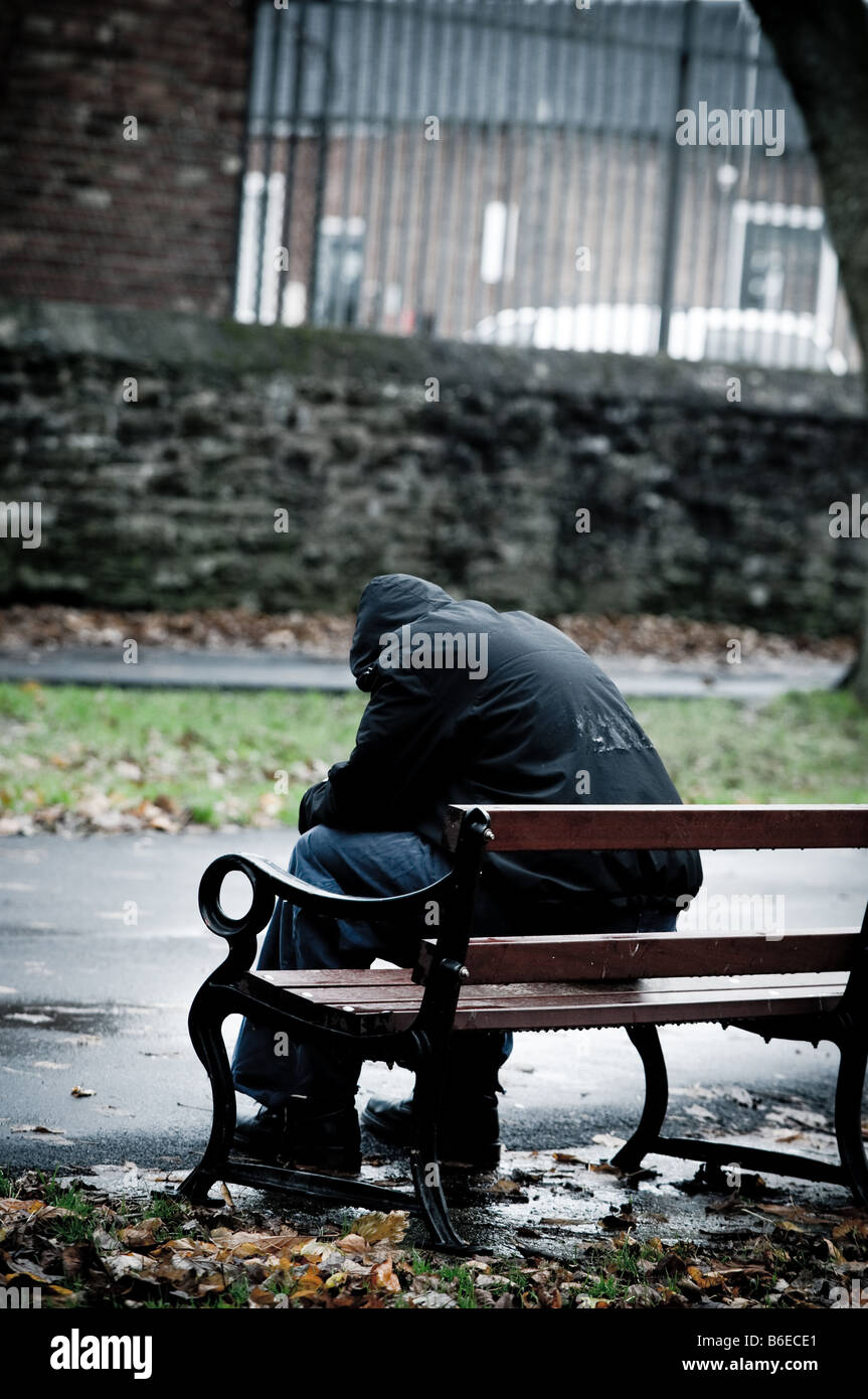 Young man wearing a hooded jacket depressed lonely alone and isolated ...