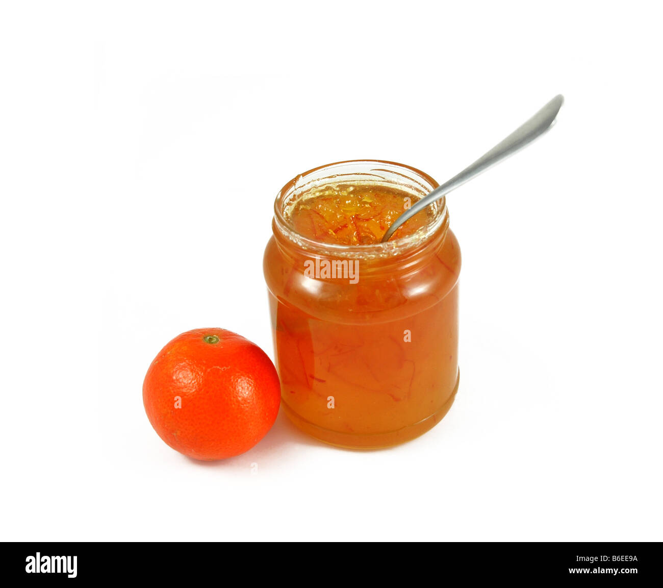 An open marmalade jar with a spoon and an orange sitting nest to it ...