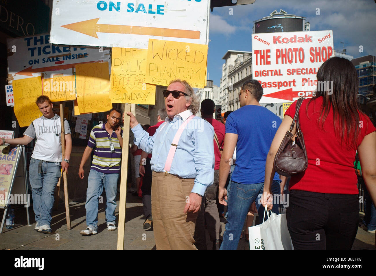 Theatre and concert ticket sellers standing with hand held placards ...