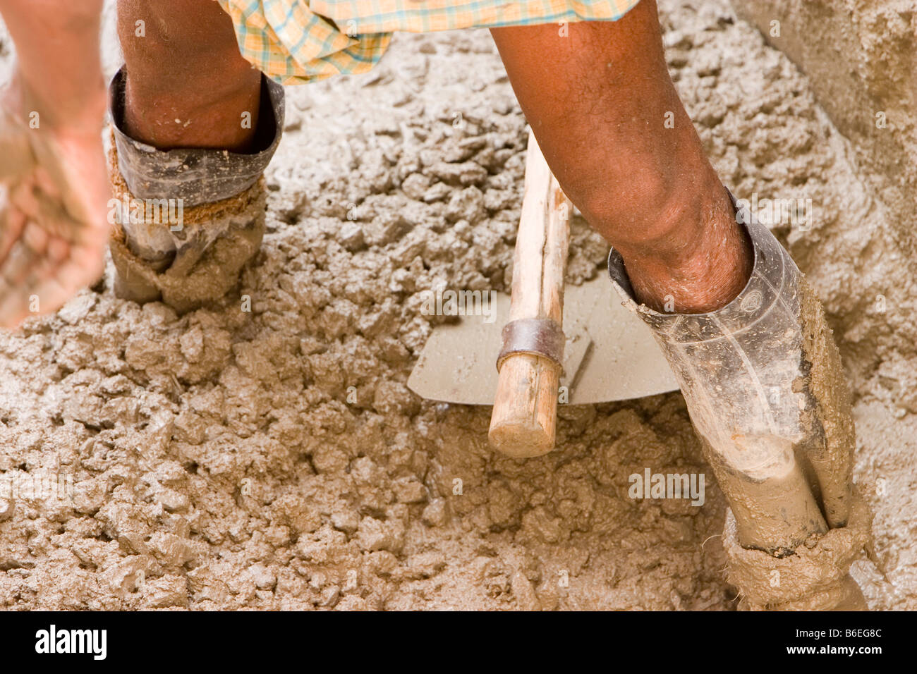 Mason mixing concrete at a building construction site in Chennai, Tamil ...
