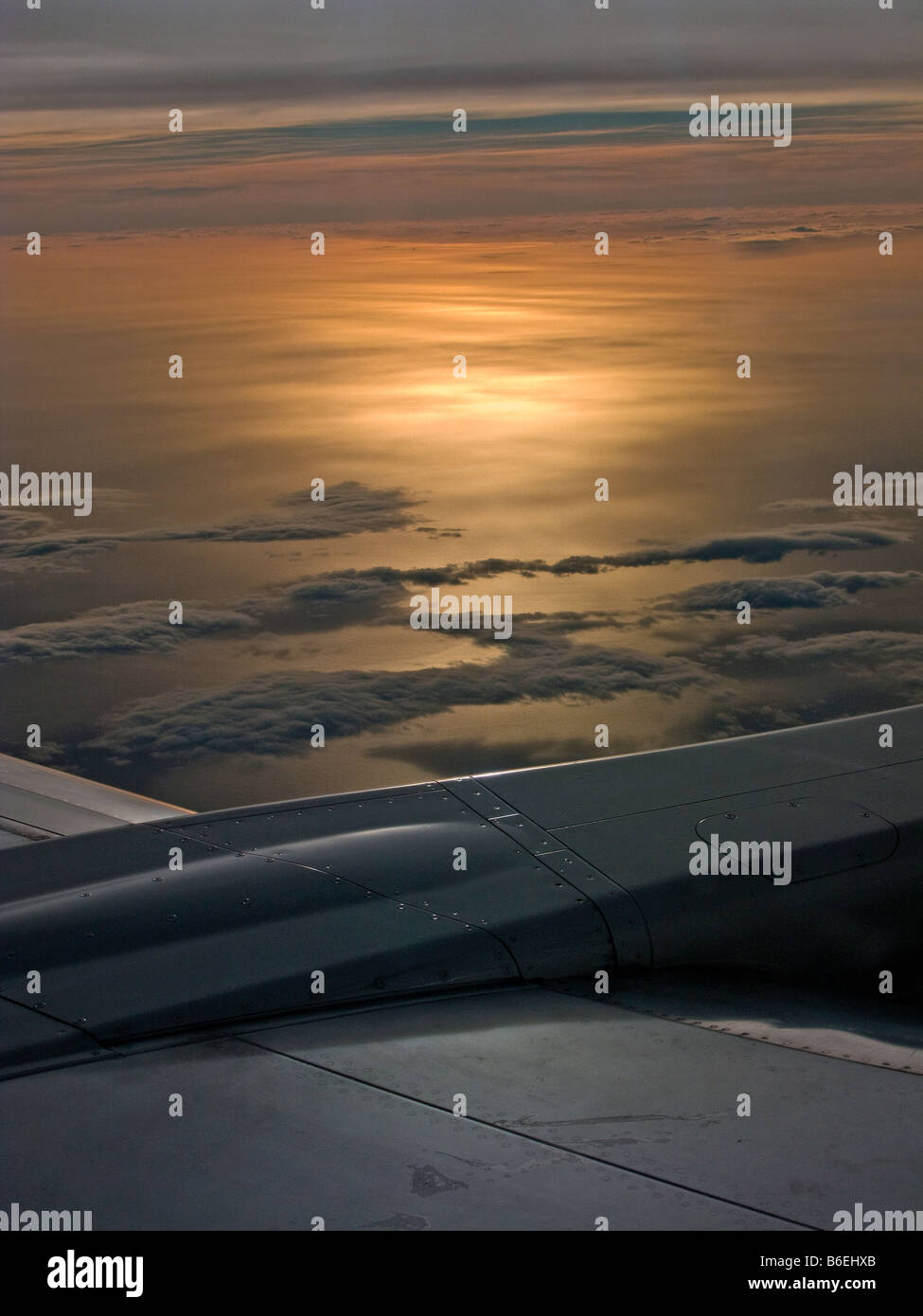 Setting sun over the sea from aircraft window Stock Photo - Alamy