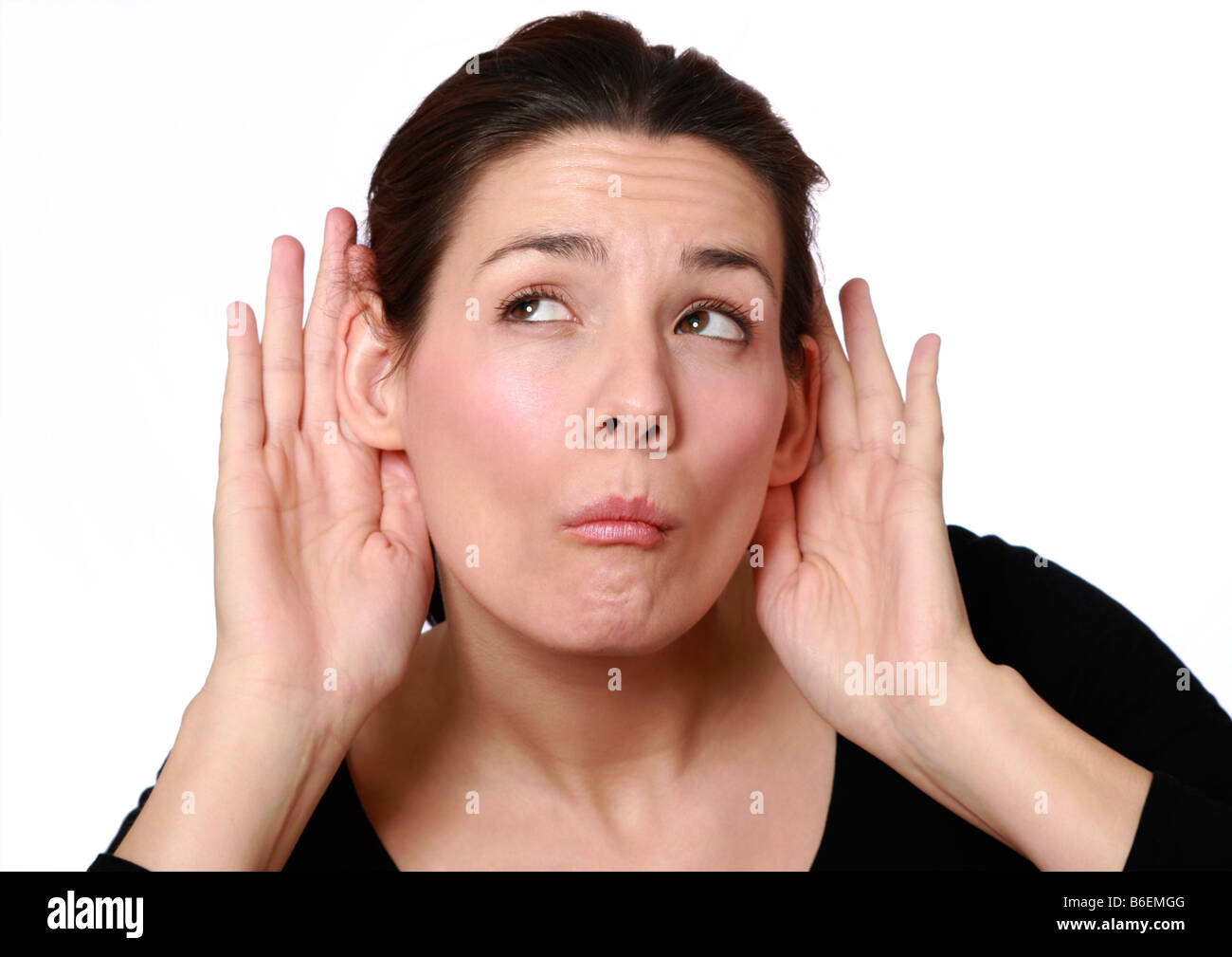 Young woman using her hands to hear more clearly Stock Photo - Alamy