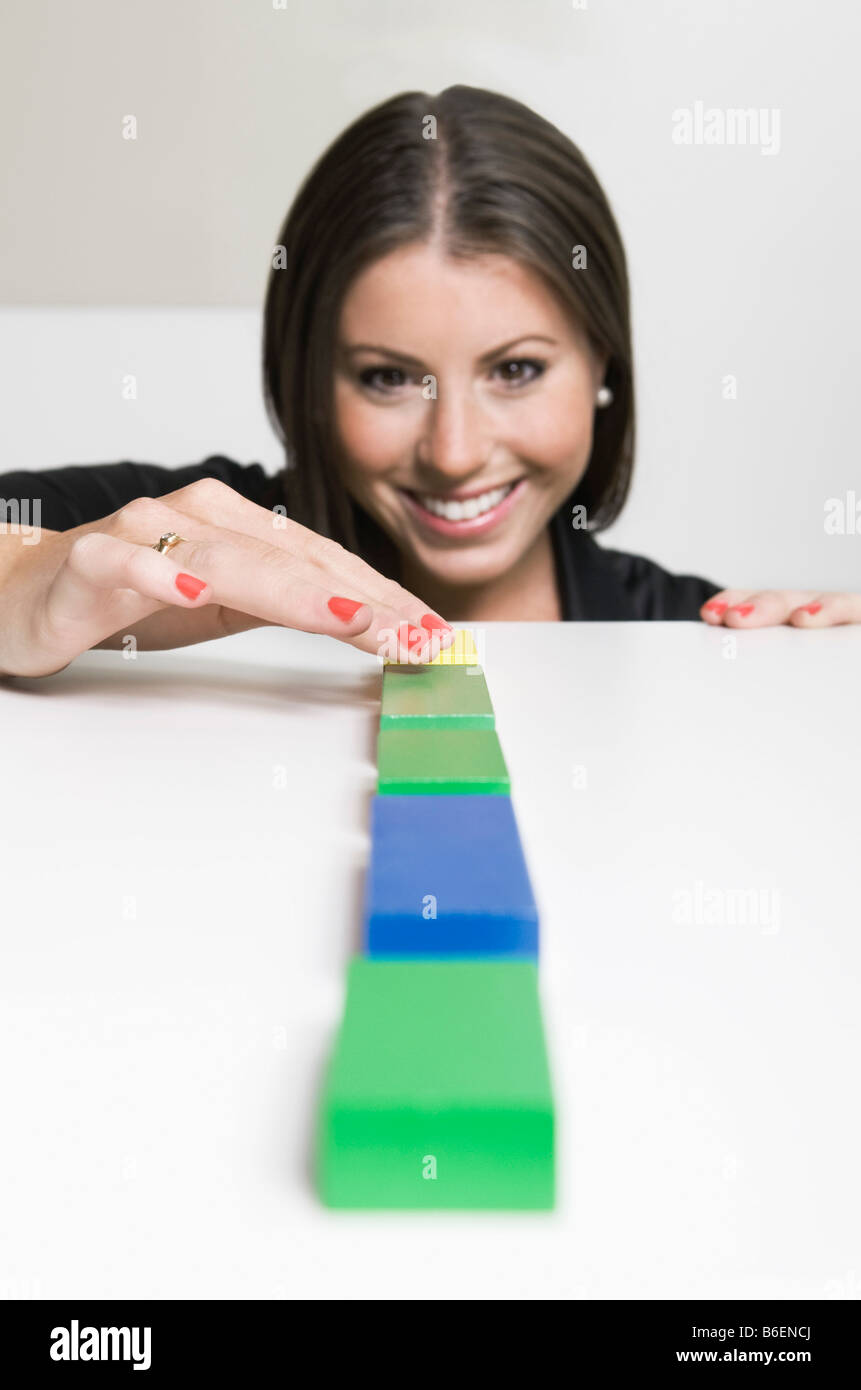 Woman placing blocks in a row Stock Photo - Alamy