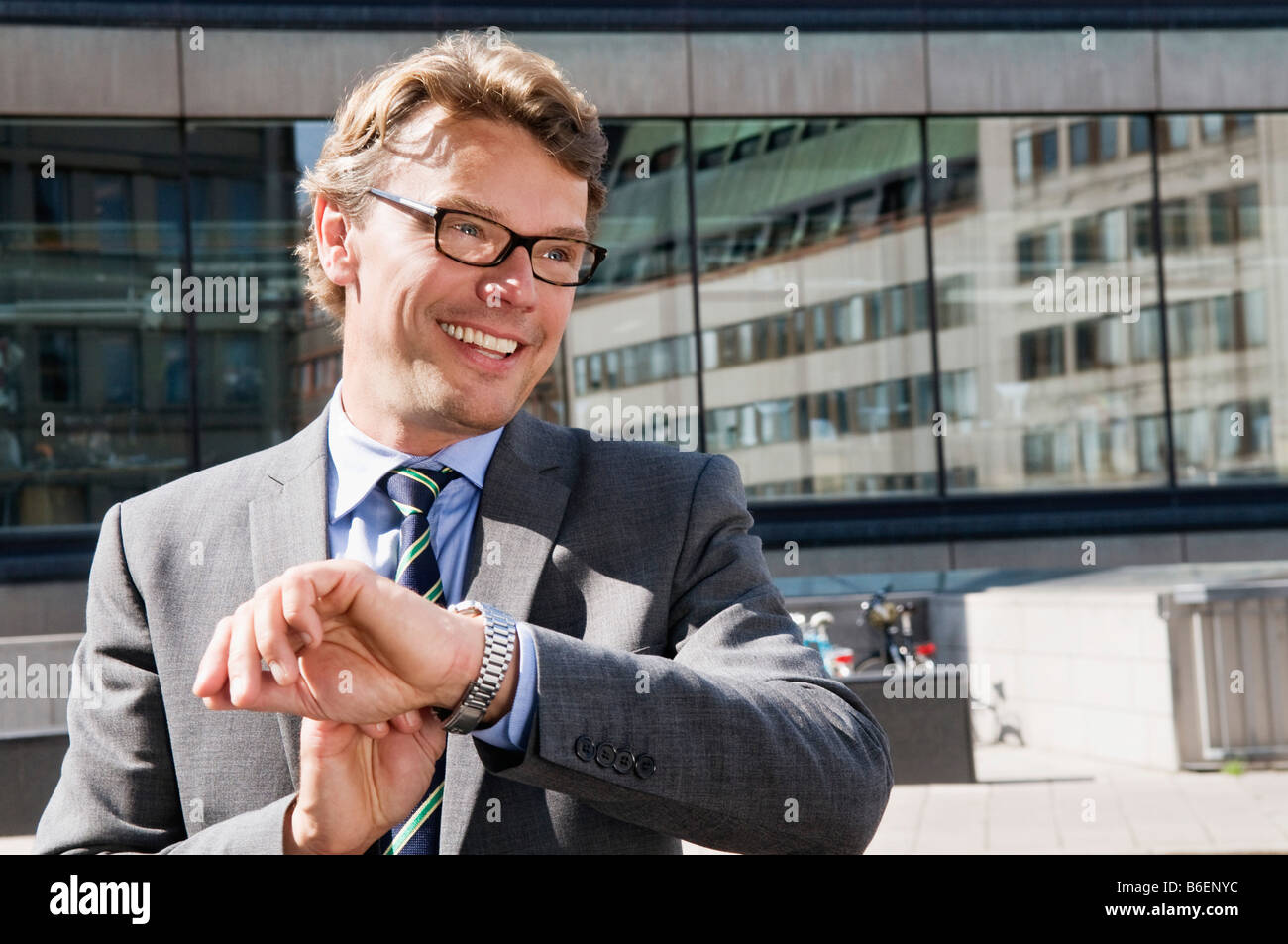 Satisfied businessman with watch Stock Photo - Alamy