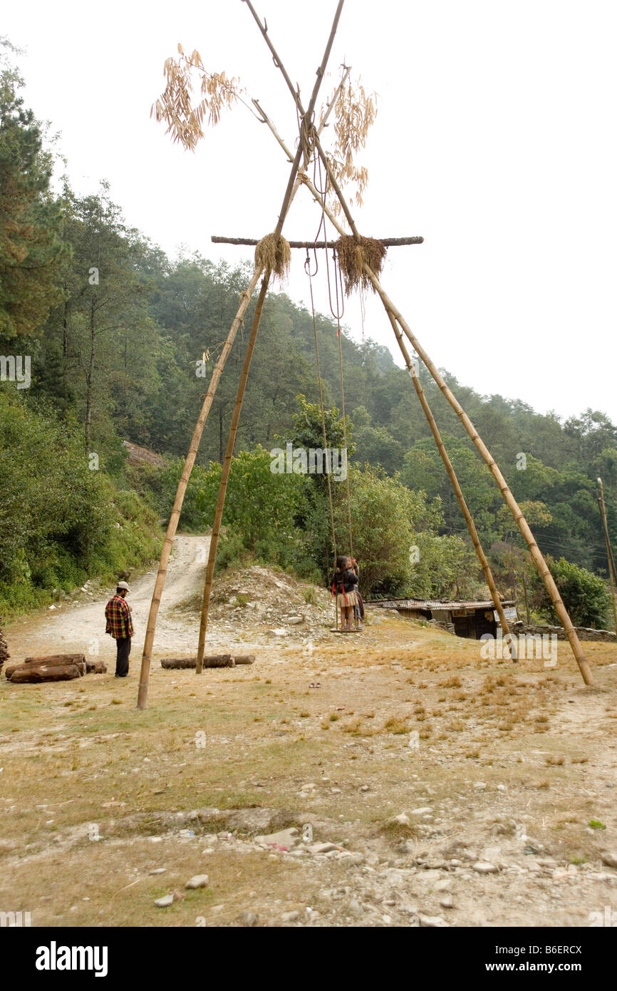 Two Nepalese children playing on a swing in the village of Dhampus in ...