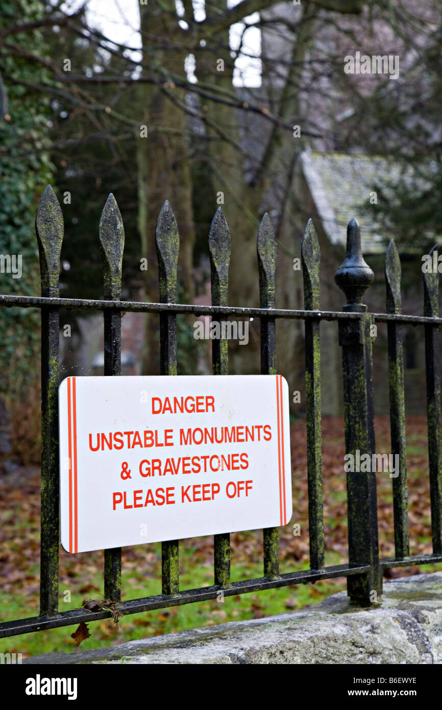 Danger unstable monuments and gravestones warning sign in churchyard ...