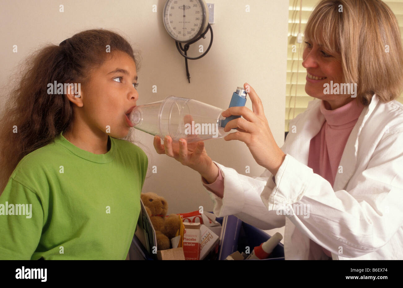 physician in asthma clinic showing young girl how to use the spacer for ...