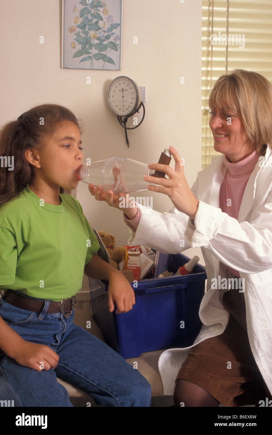 physician in asthma clinic showing young girl how to use the spacer for ...